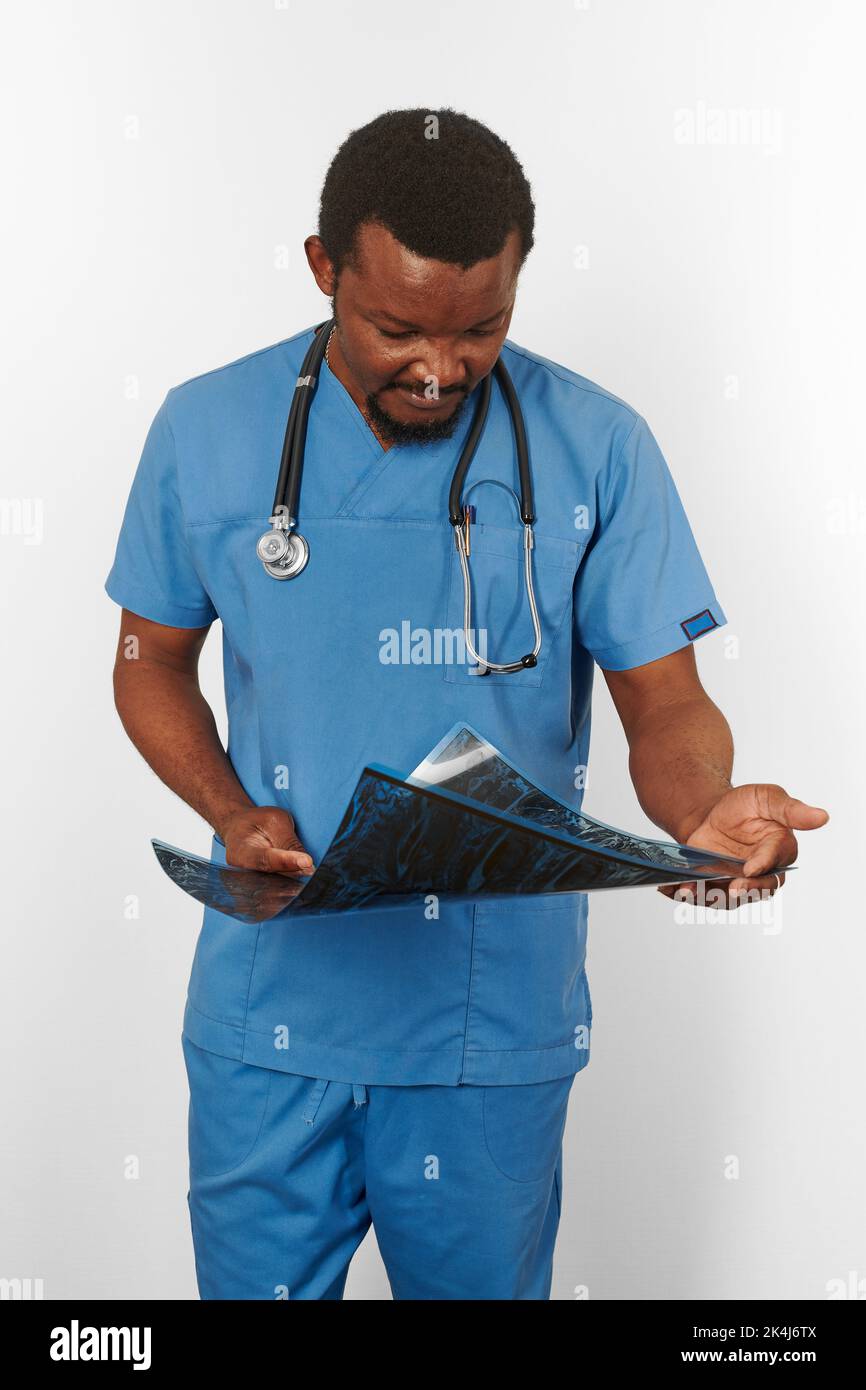 Black surgeon doctor bearded man in blue coat with stethoscope holds X ...