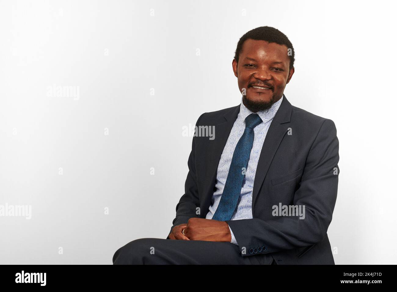Smiling african american black man in business suit sitting on chair ...