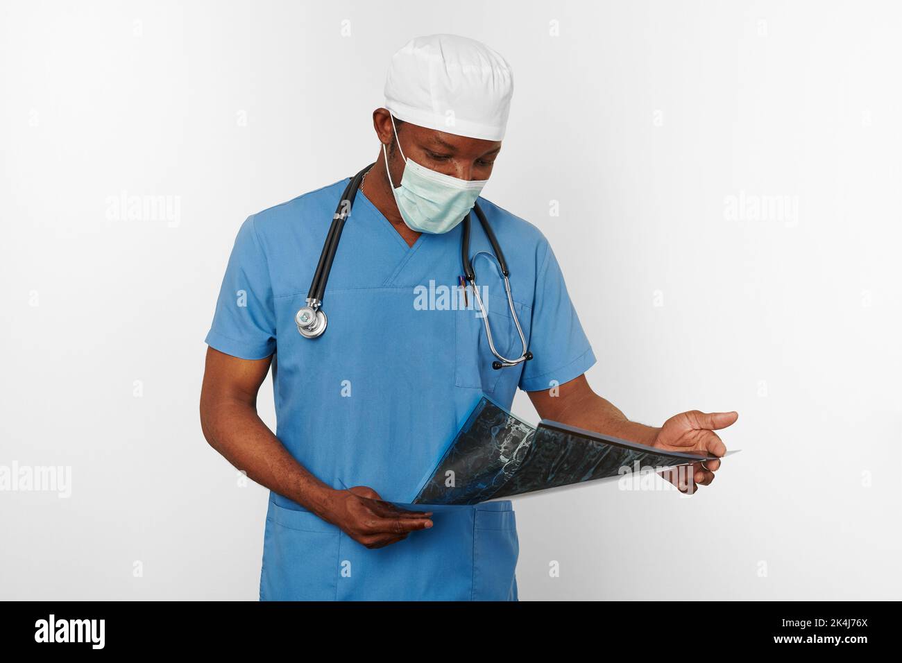 Black surgeon doctor man in blue coat white cap and surgeon mask holds ...