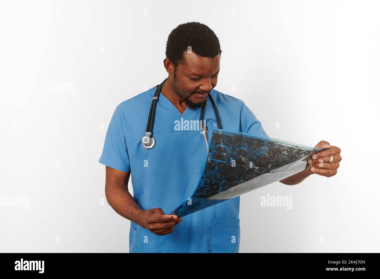 Black surgeon doctor bearded man in blue coat with stethoscope holds X ...