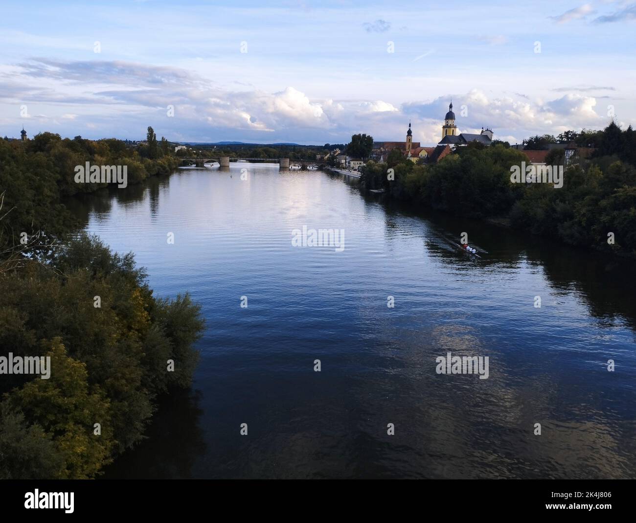 A high angle shot of a river between green trees in Kitzingen, Germany ...