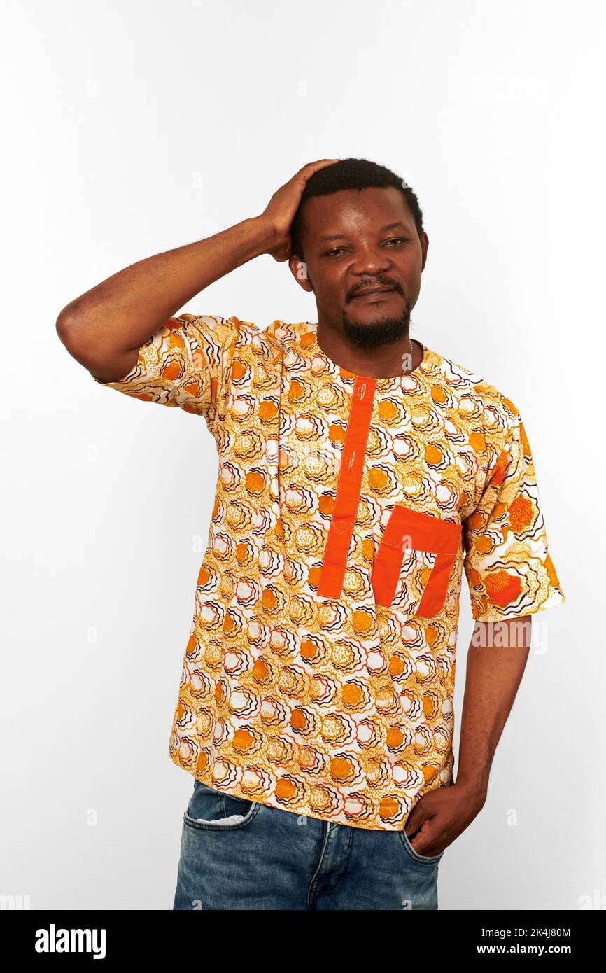 Thoughtful black man in African bright clothes isolated on white ...