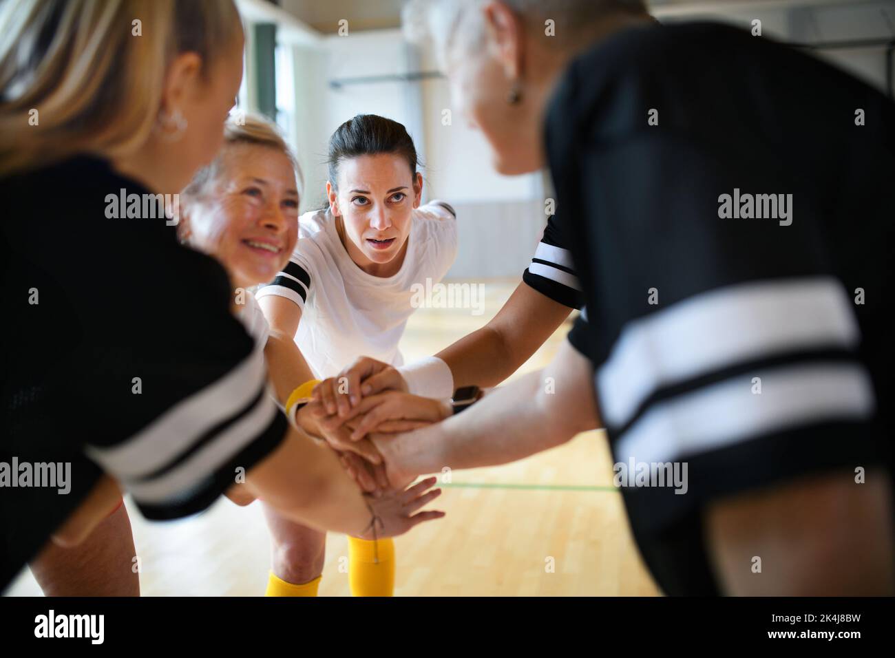 Group of multigenerational women in gym stacking hands together, sport ...