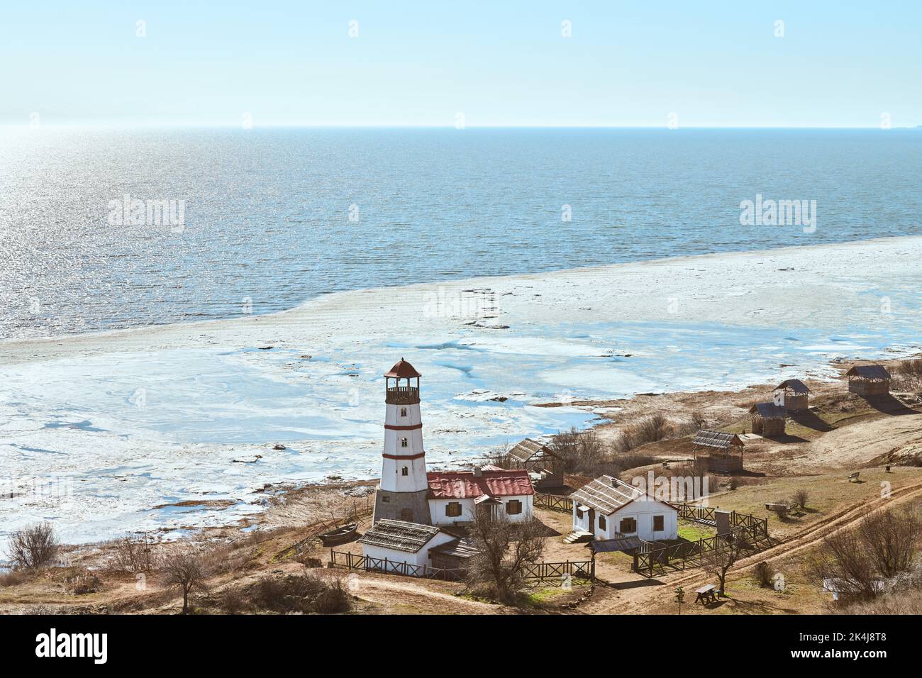 Atmospheric romantic view to white red lighthouse with farm utility ...