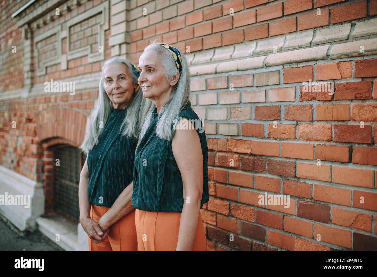 Senior women twins,in same clothes standing and posing in front of ...