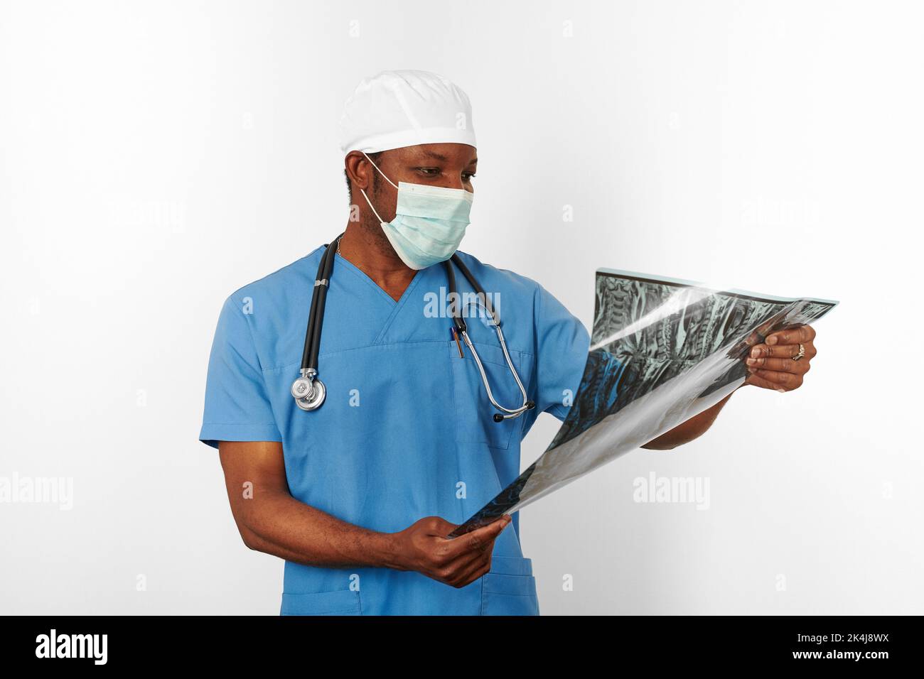 Black surgeon doctor man in blue coat white cap and surgeon mask holds ...