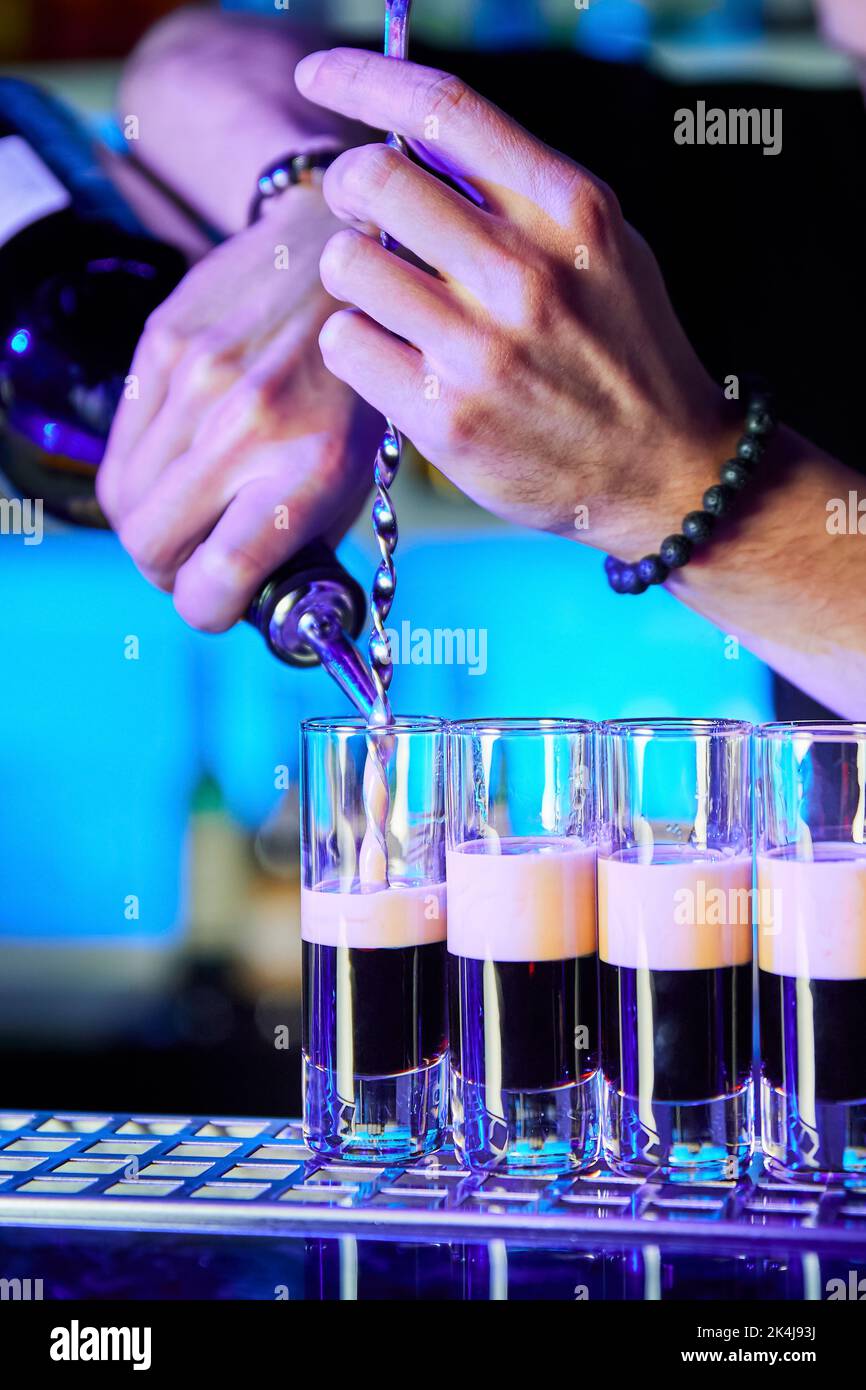 Bartender prepares alcoholic shots on bar counter Stock Photo - Alamy