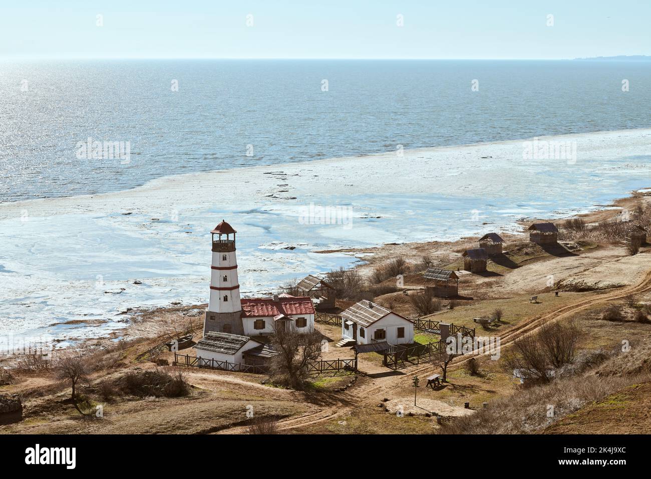 Atmospheric romantic view to white red lighthouse with farm utility ...