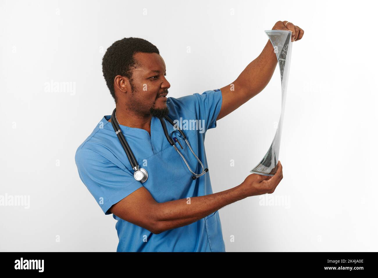 Black surgeon doctor bearded man in blue coat with stethoscope holds X ...