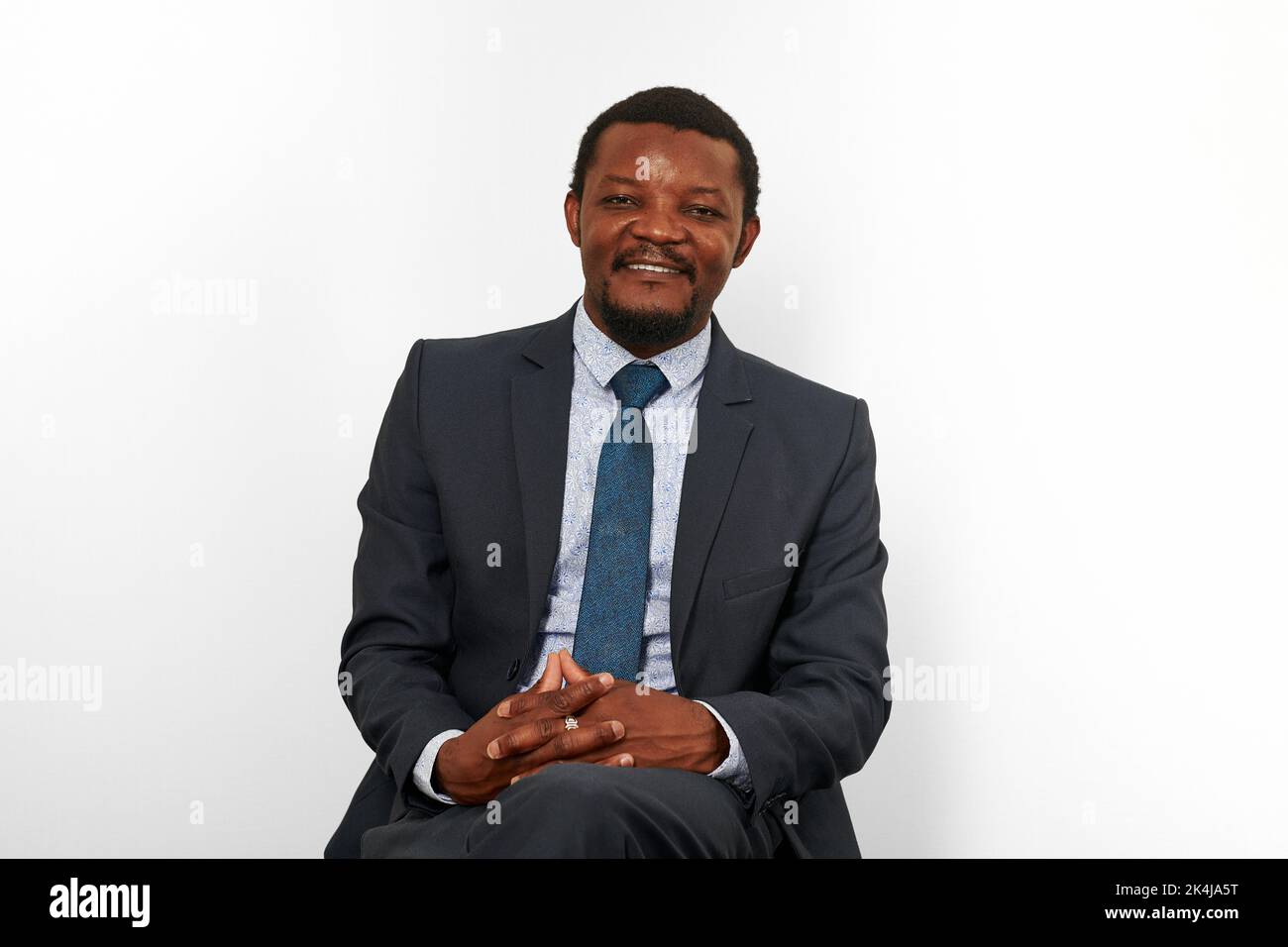 Smiling african american black man in business suit sitting on chair ...