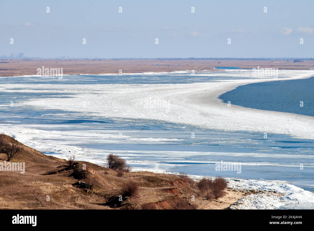 February seashore with melting ice near shore, seasonally nature ...