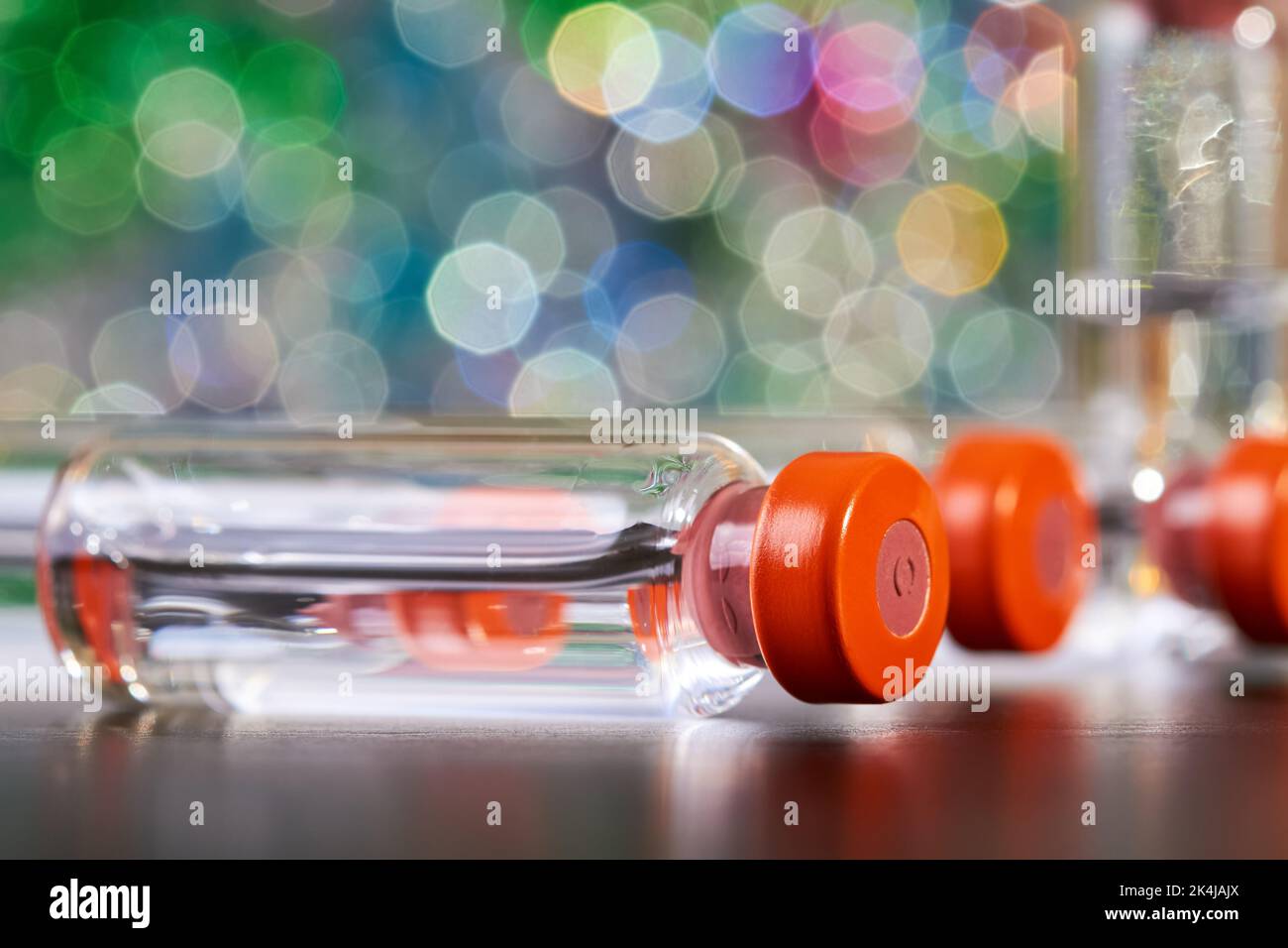 Close-up of medicine for injection in glass vials on a colorful ...
