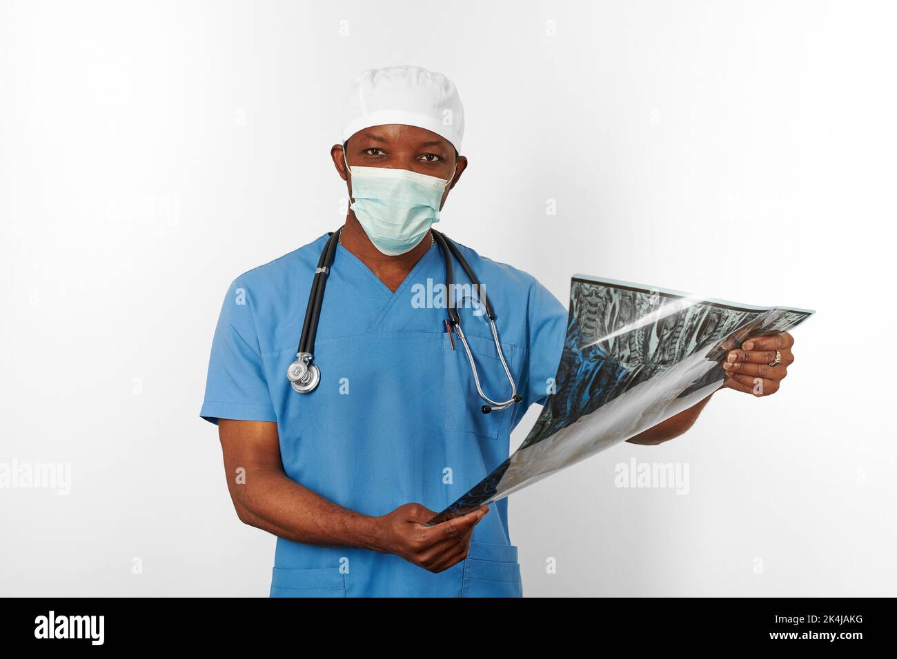 Black surgeon doctor man in blue coat white cap and surgeon mask holds ...