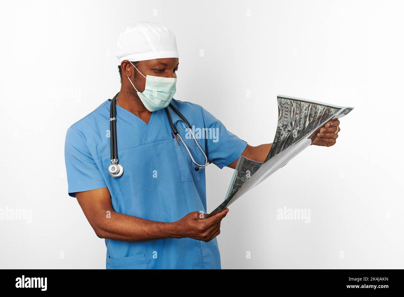 Black surgeon doctor man in blue coat white cap and surgeon mask holds ...