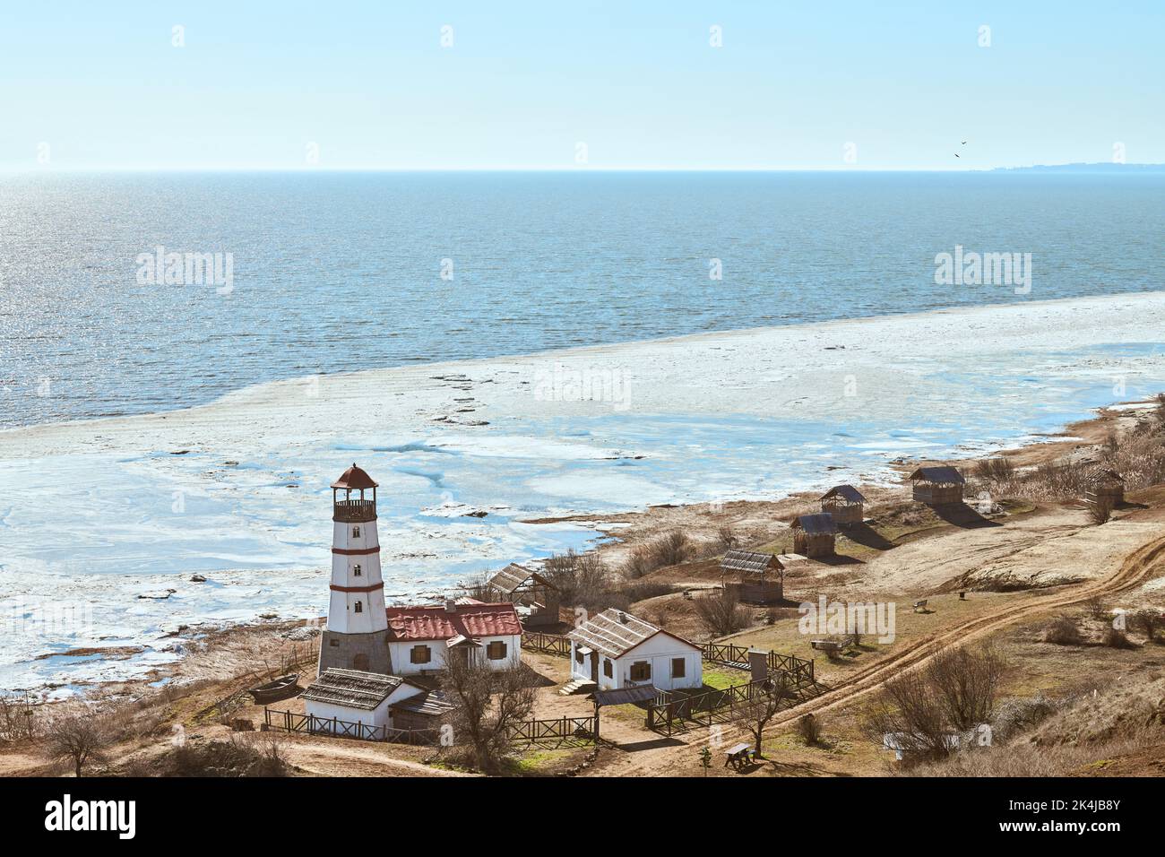 Atmospheric romantic view to white red lighthouse with farm utility ...