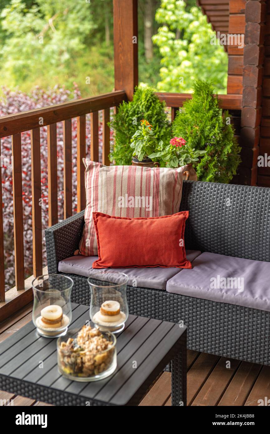 Cozy terrace with table and sofa at wooden cottage house surrounded by ...