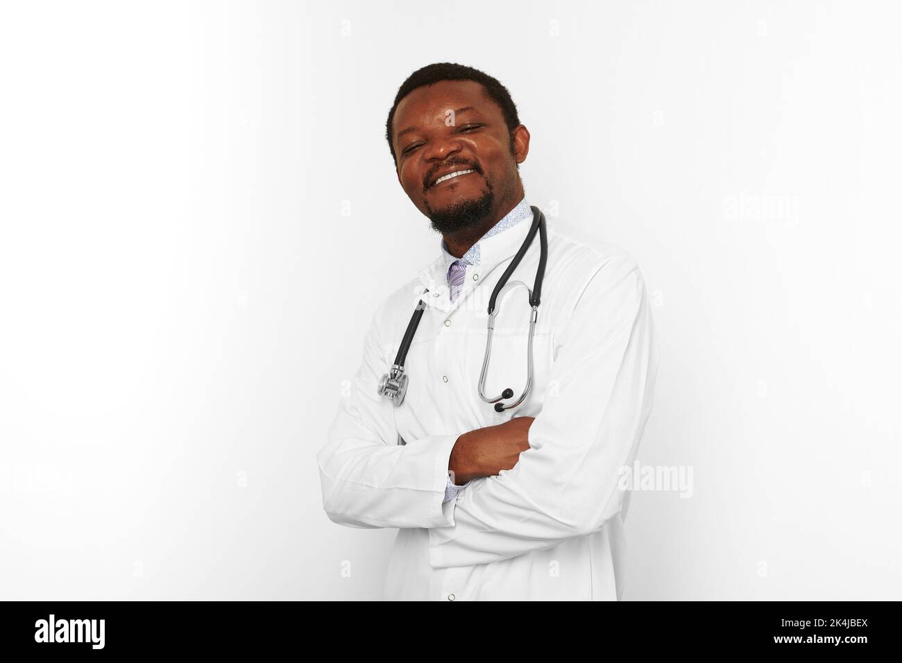 Smiling black bearded doctor man crossed arms in white coat with ...