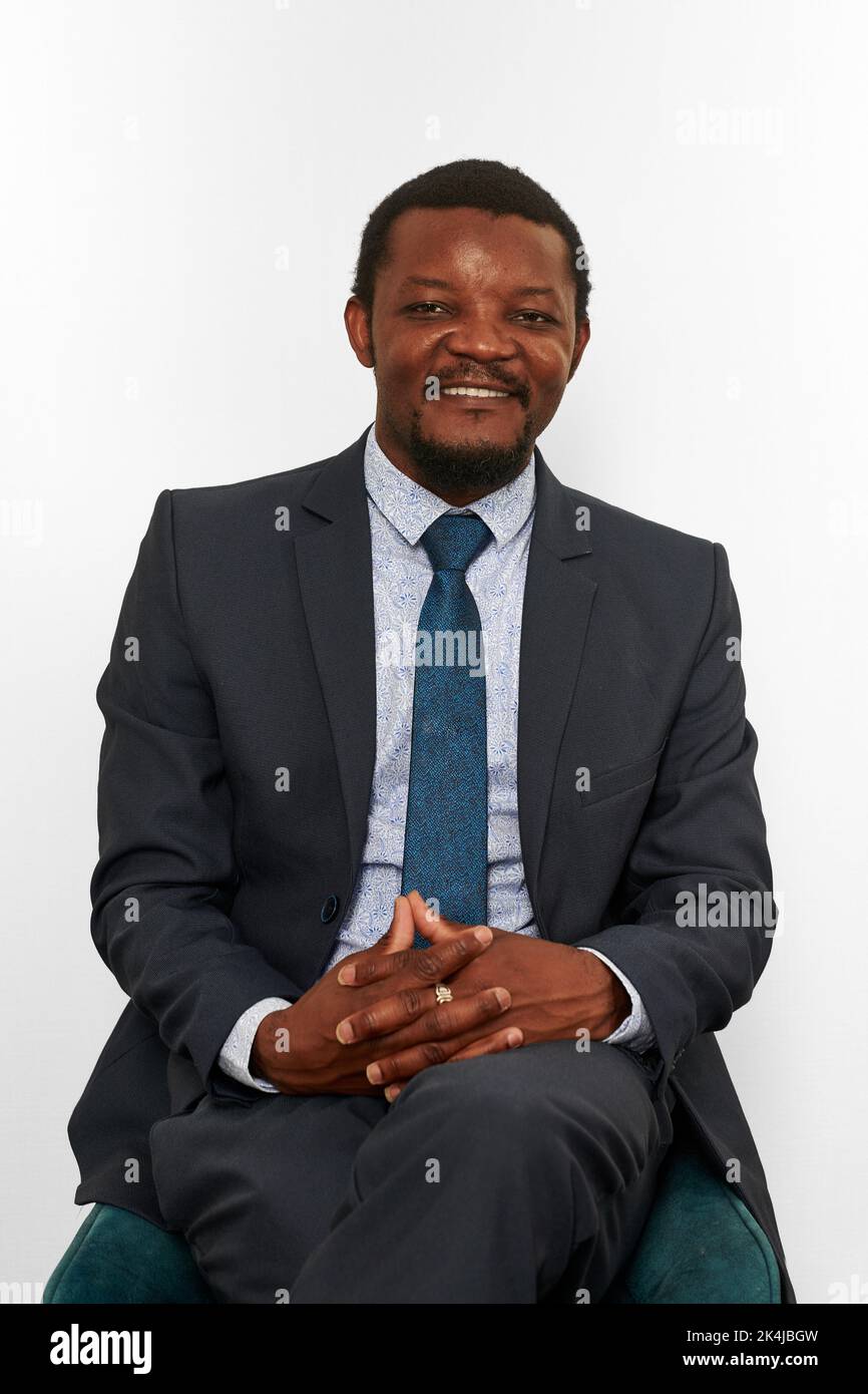 Smiling african american black man in business suit sitting on chair ...