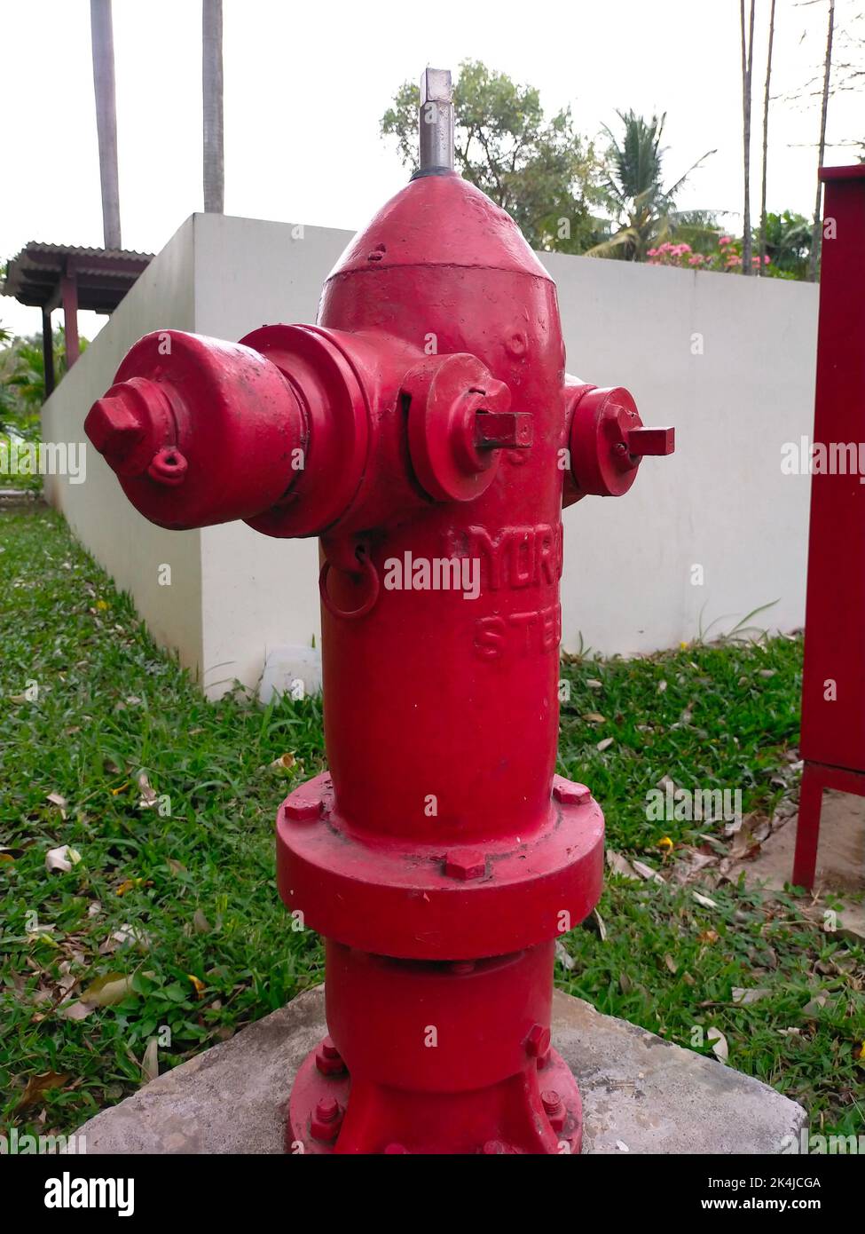 A vertical closeup of a hydrant pillar on the ground used for emergency ...