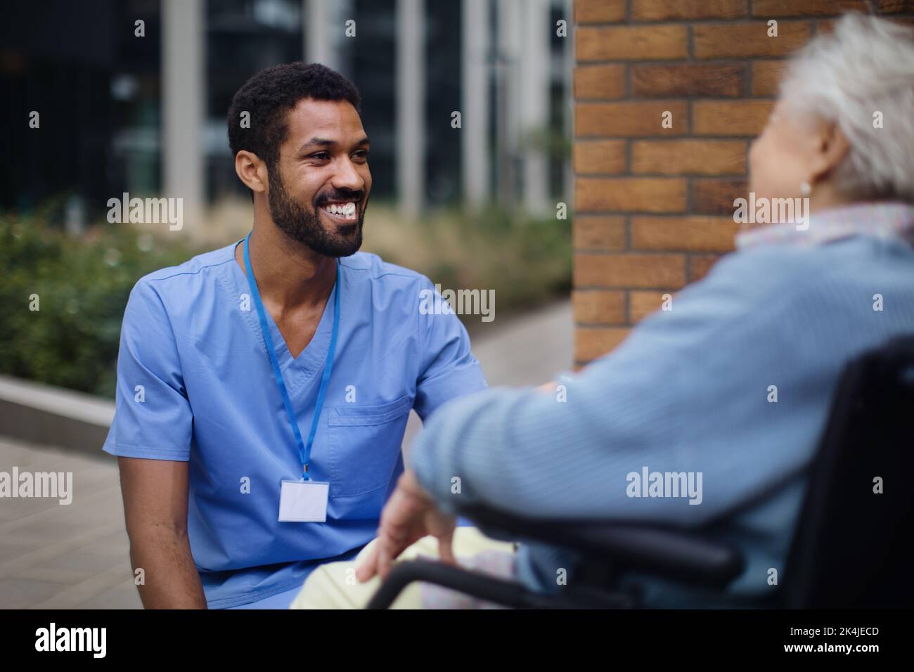 Happy senior woman at wheelchair spending time outside with her ...