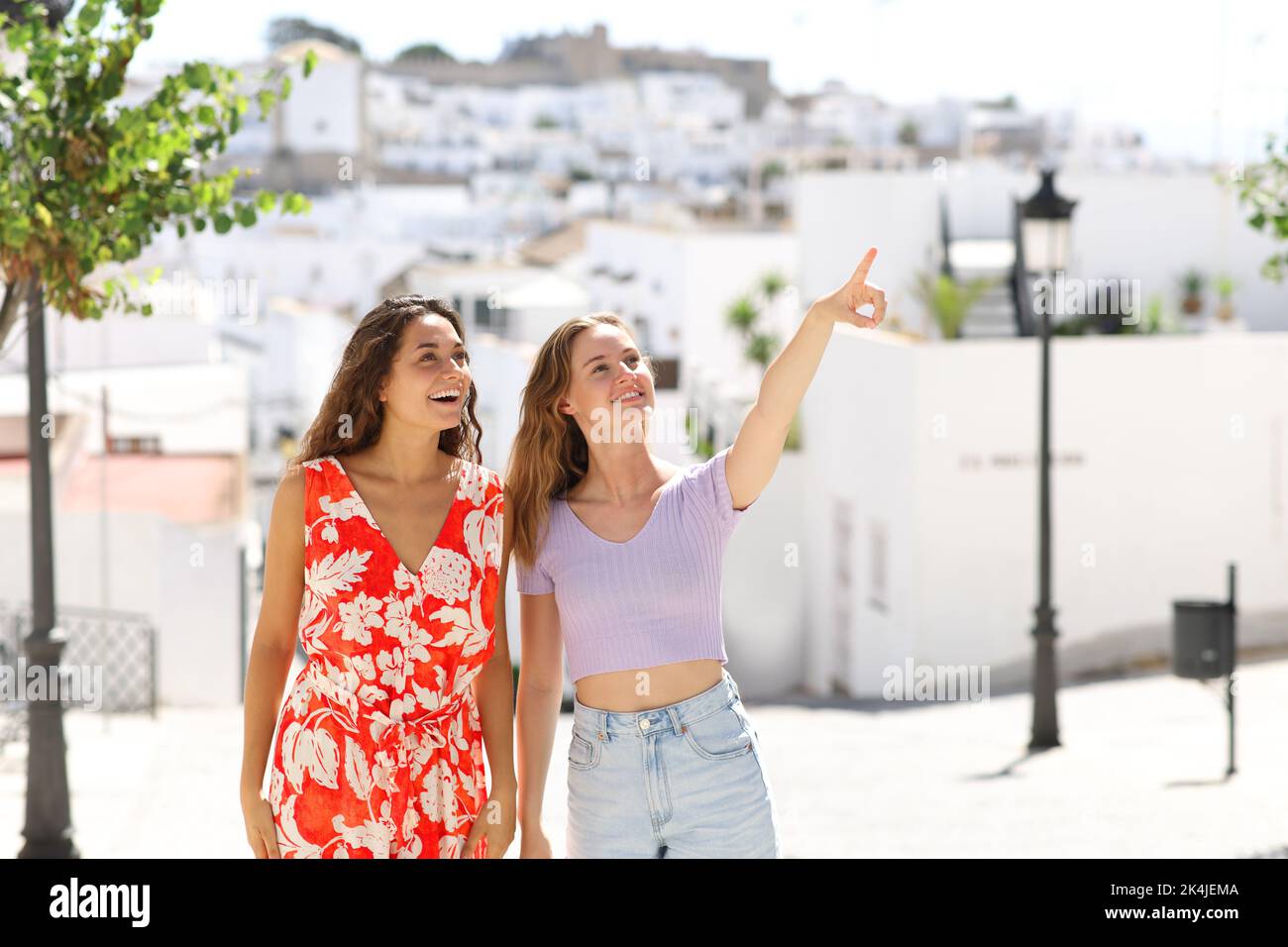 Two friends pointing standing in a town street on summer Stock Photo ...