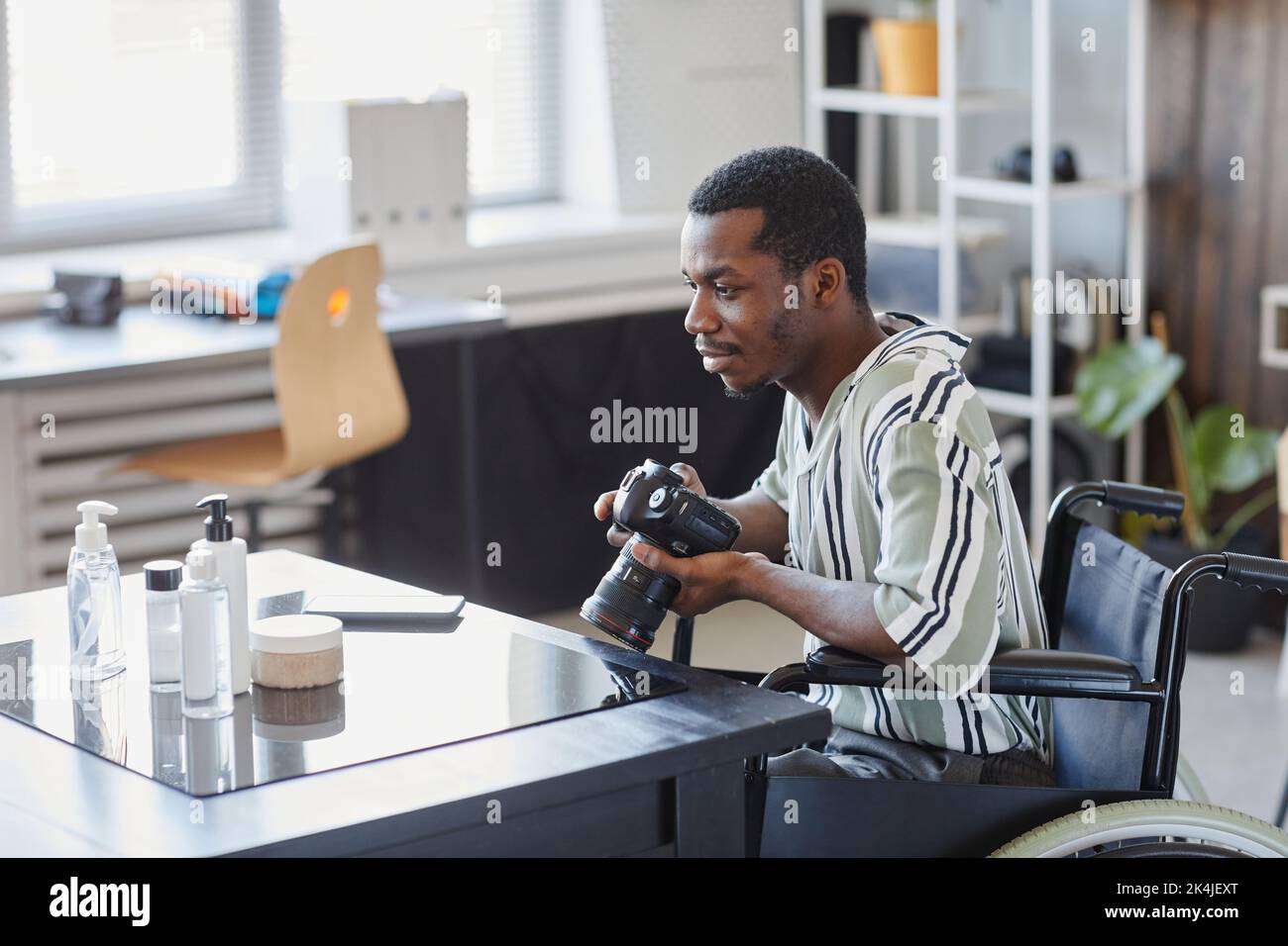 Side view portrait of young black man as photographer with disability ...