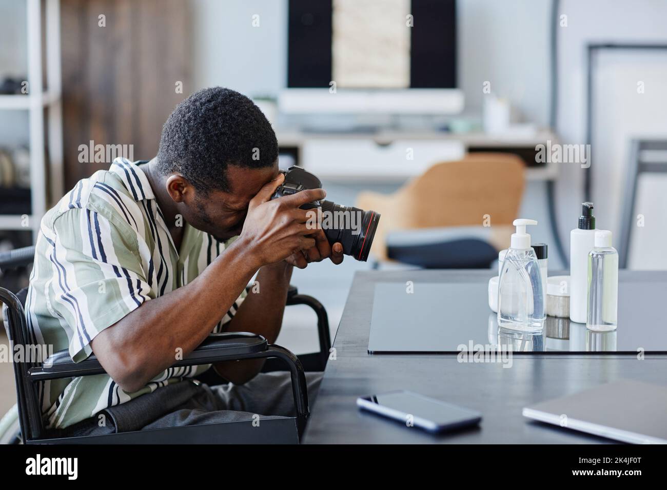 Side view portrait of young black man in wheelchair as photographer ...