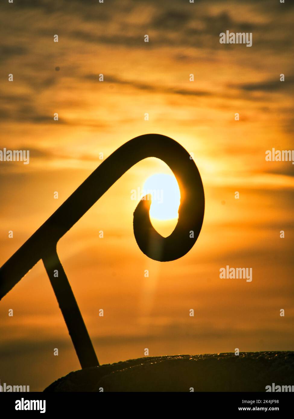 A shallow focus shot of silhouette of spiral shape with sunset ...
