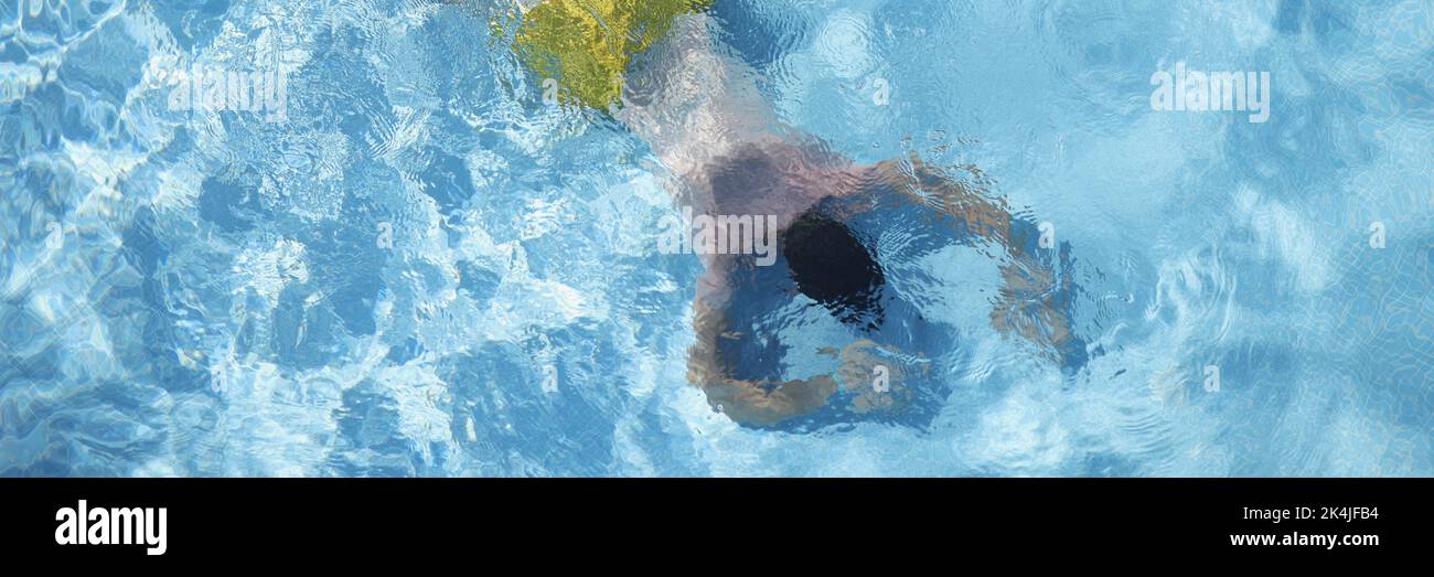 Male person in swimming pool floating on water on belly, diving on ...