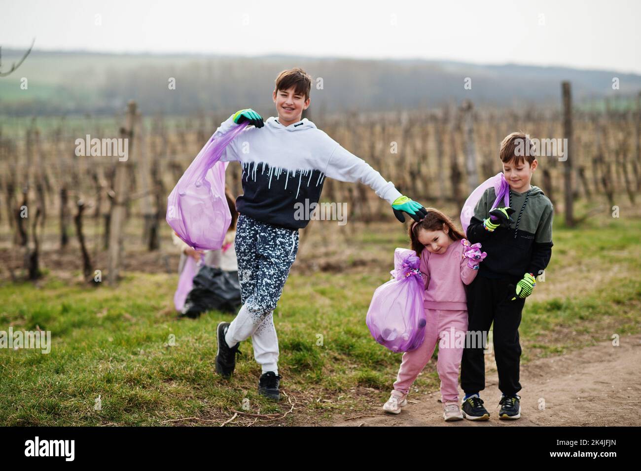 Children with trash bag collecting garbage while cleaning in the ...