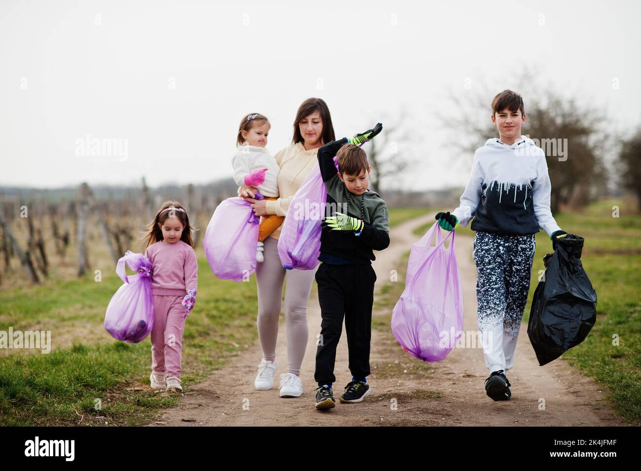 Family with trash bag collecting garbage while cleaning in the ...