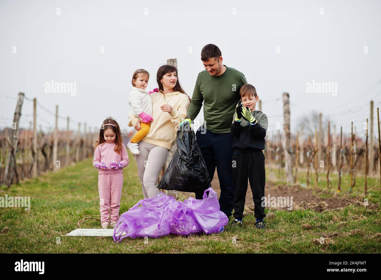 Family with trash bag collecting garbage while cleaning in the ...