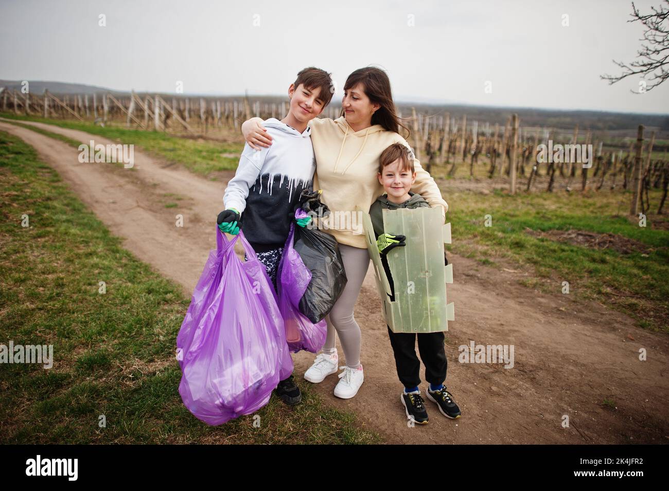 Family with trash bag collecting garbage while cleaning in the ...