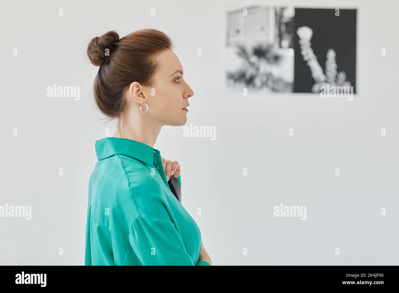 Minimal side view portrait of young woman looking at art in photo ...