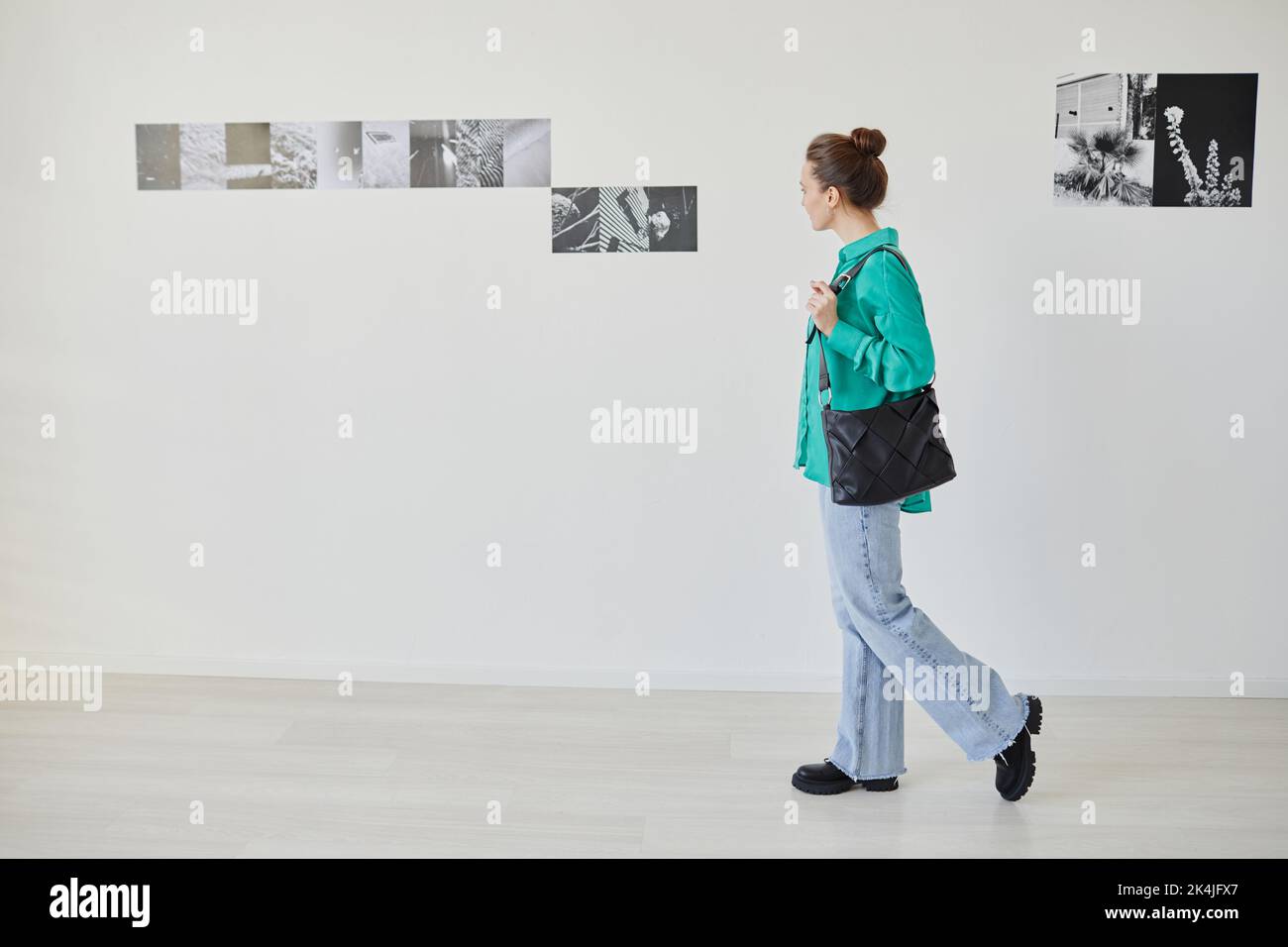 Minimal full length portrait of young woman visiting photo gallery and ...