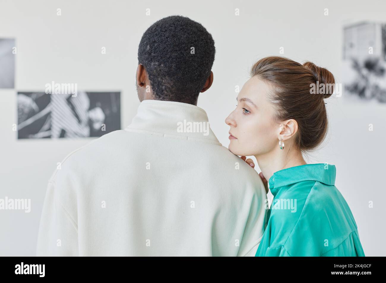 Minimal back view of young couple looking at photo gallery in museum ...