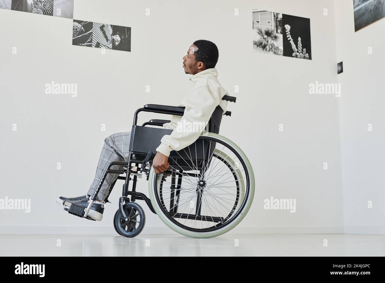 Side view portrait of black young man using wheelchair while visiting ...