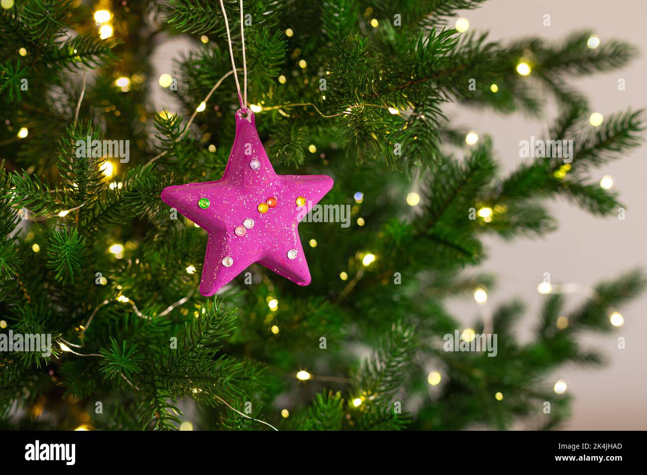 kids christmas craft hanging on Christmas tree with lights Stock Photo ...
