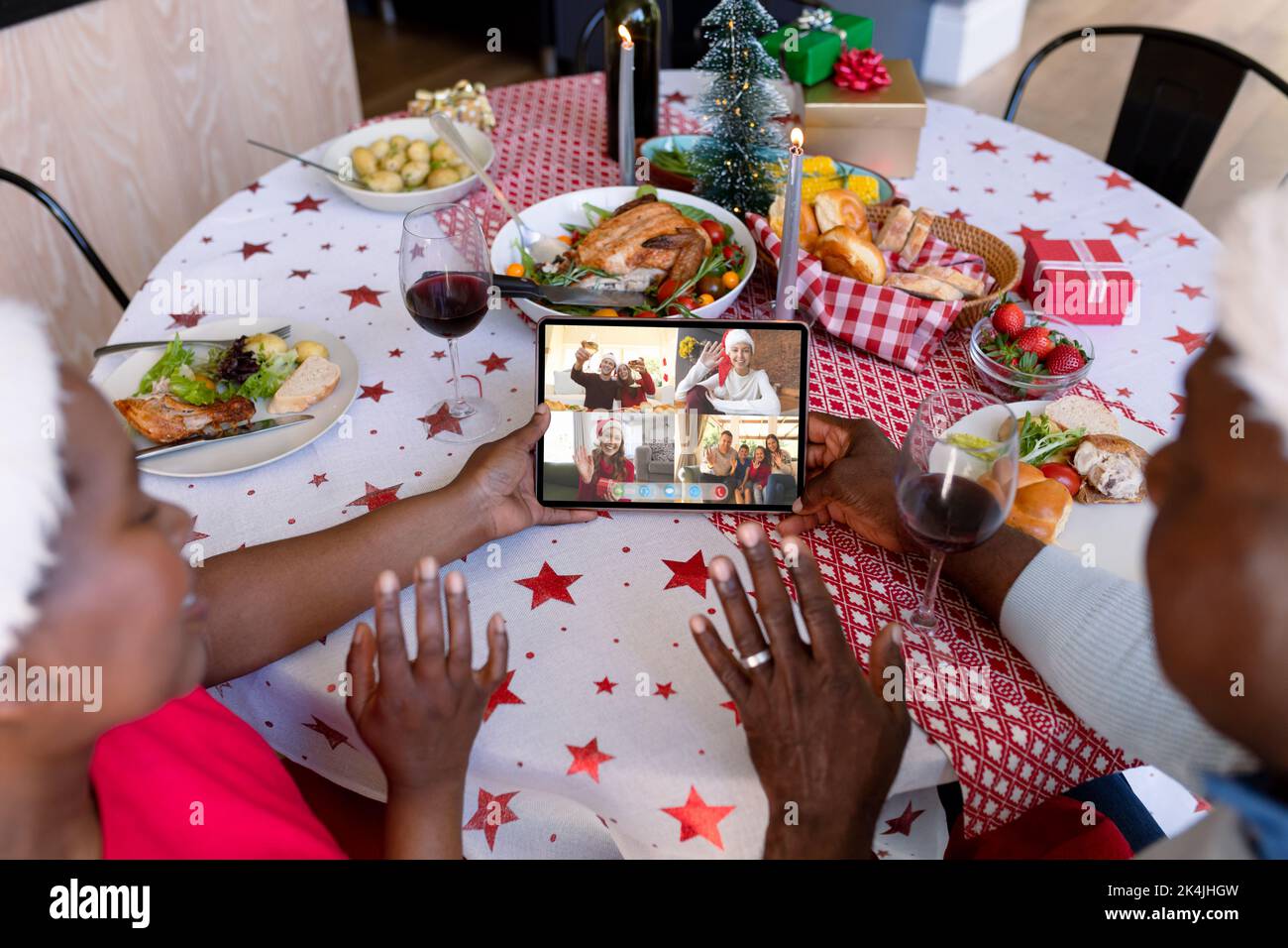 Waving african american senior couple making tablet christmas group ...