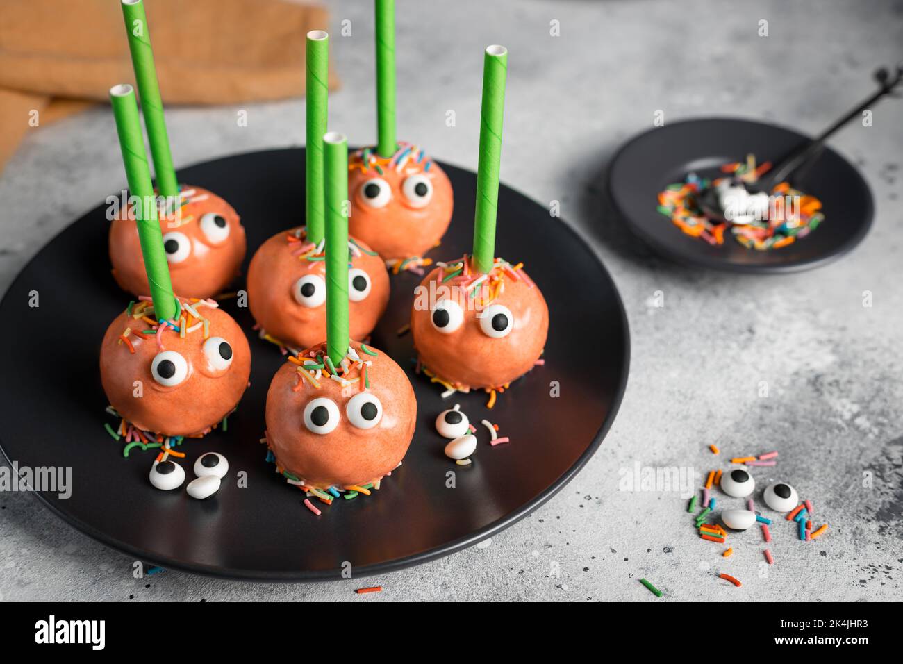 Pumpkin cake pops with funny faces on dark plate Stock Photo - Alamy
