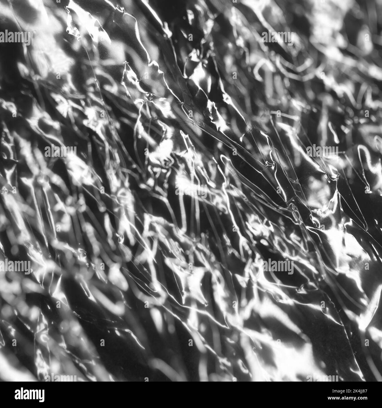 Abstracted shapes of light and shadow on creases and folds in scrunched ...