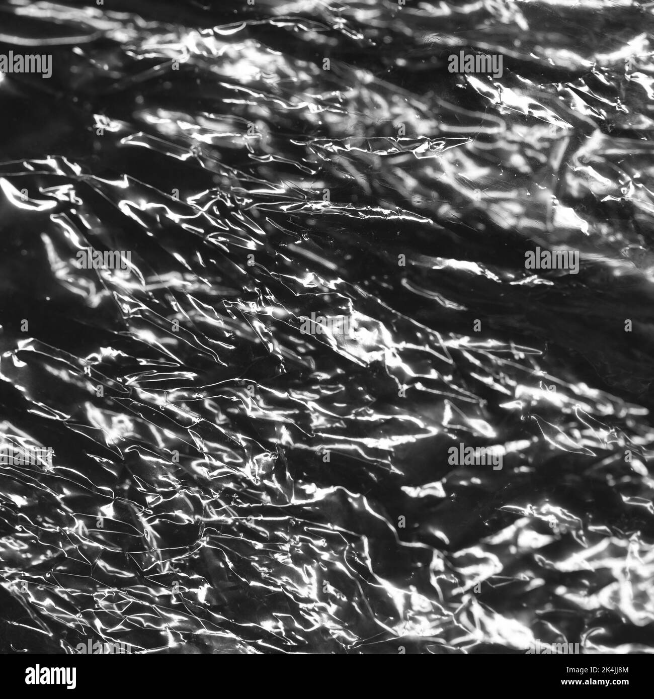 Abstracted shapes of light and shadow on creases and folds in scrunched ...