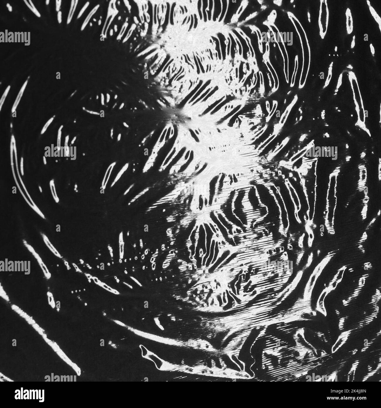 Reflected light and shadow on creases and folds in black plastic ...