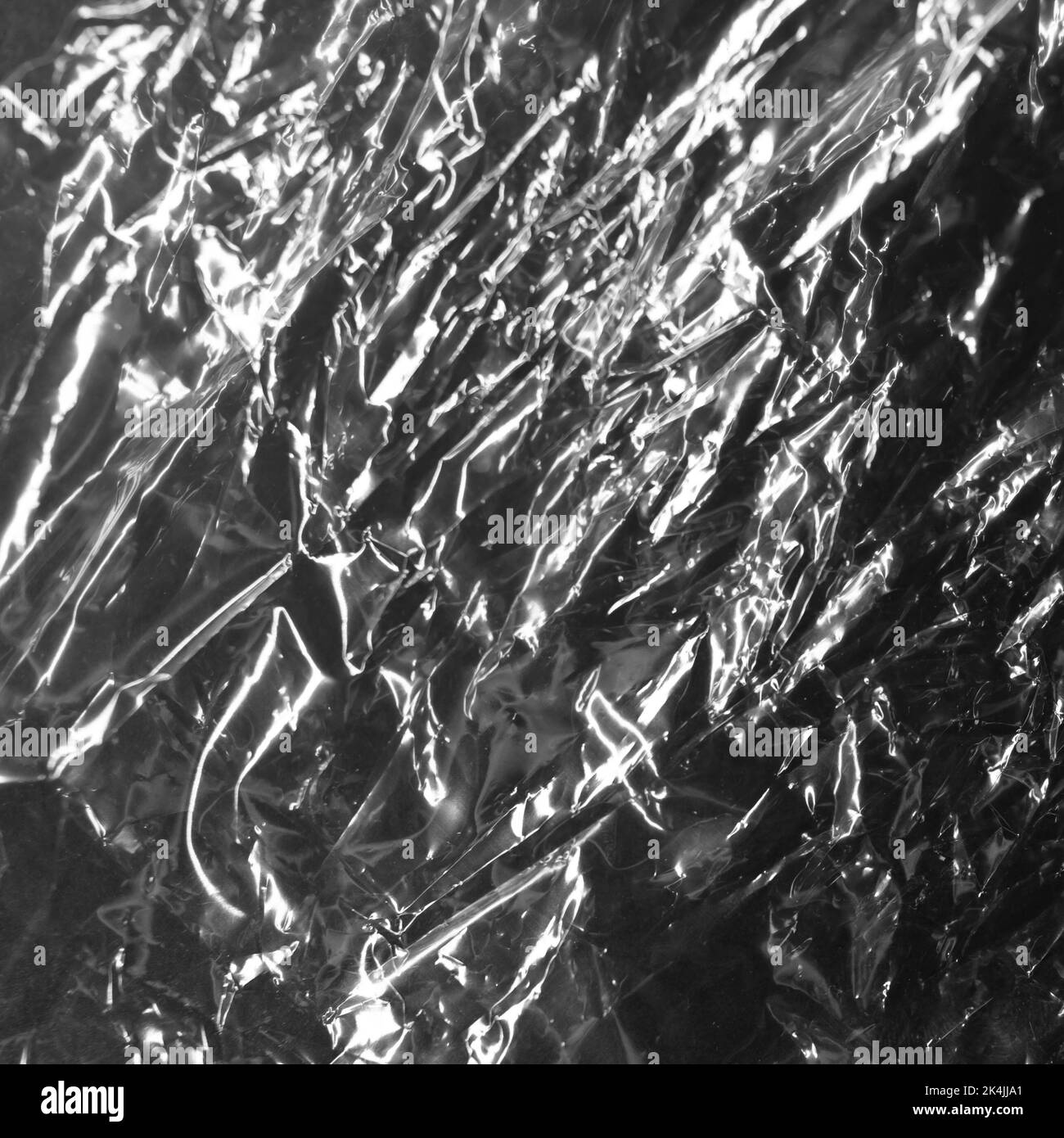 Abstracted shapes of light and shadow on creases and folds in scrunched ...