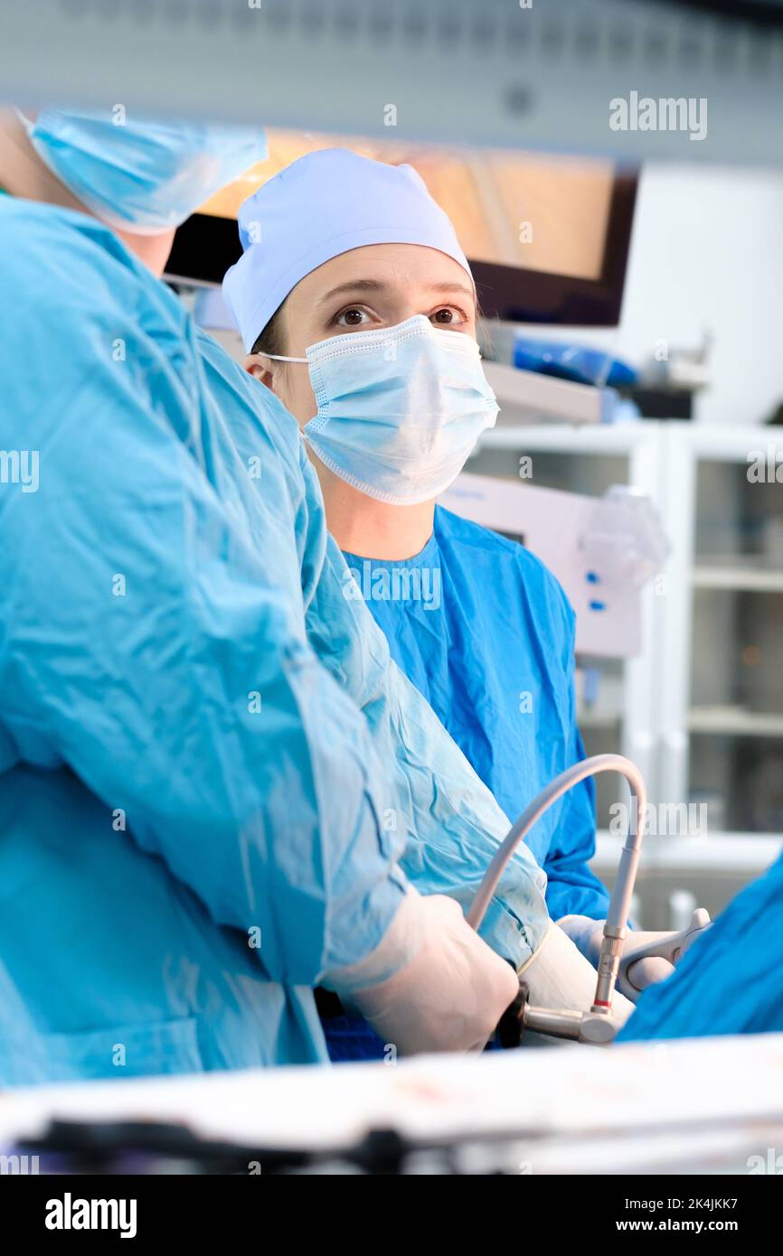 Focused look of female surgeon during surgery. A female doctor performs ...
