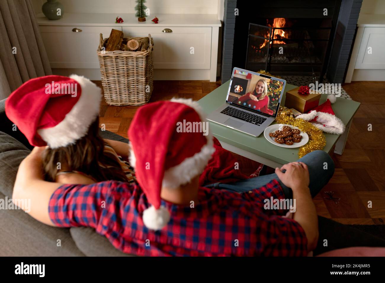 Caucasian couple in santa hats on christmas video call on laptop with ...