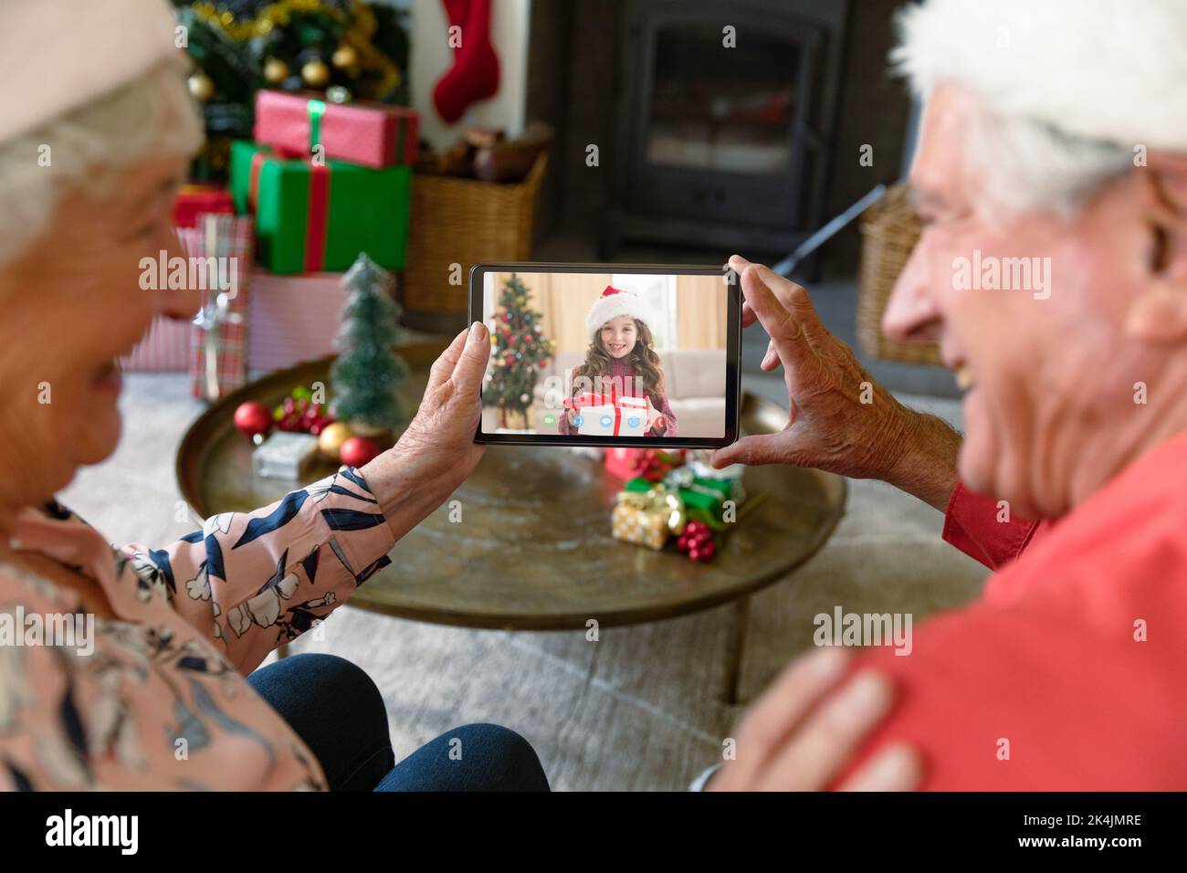 Caucasian senior grandparents in santa hats on christmas video call on ...