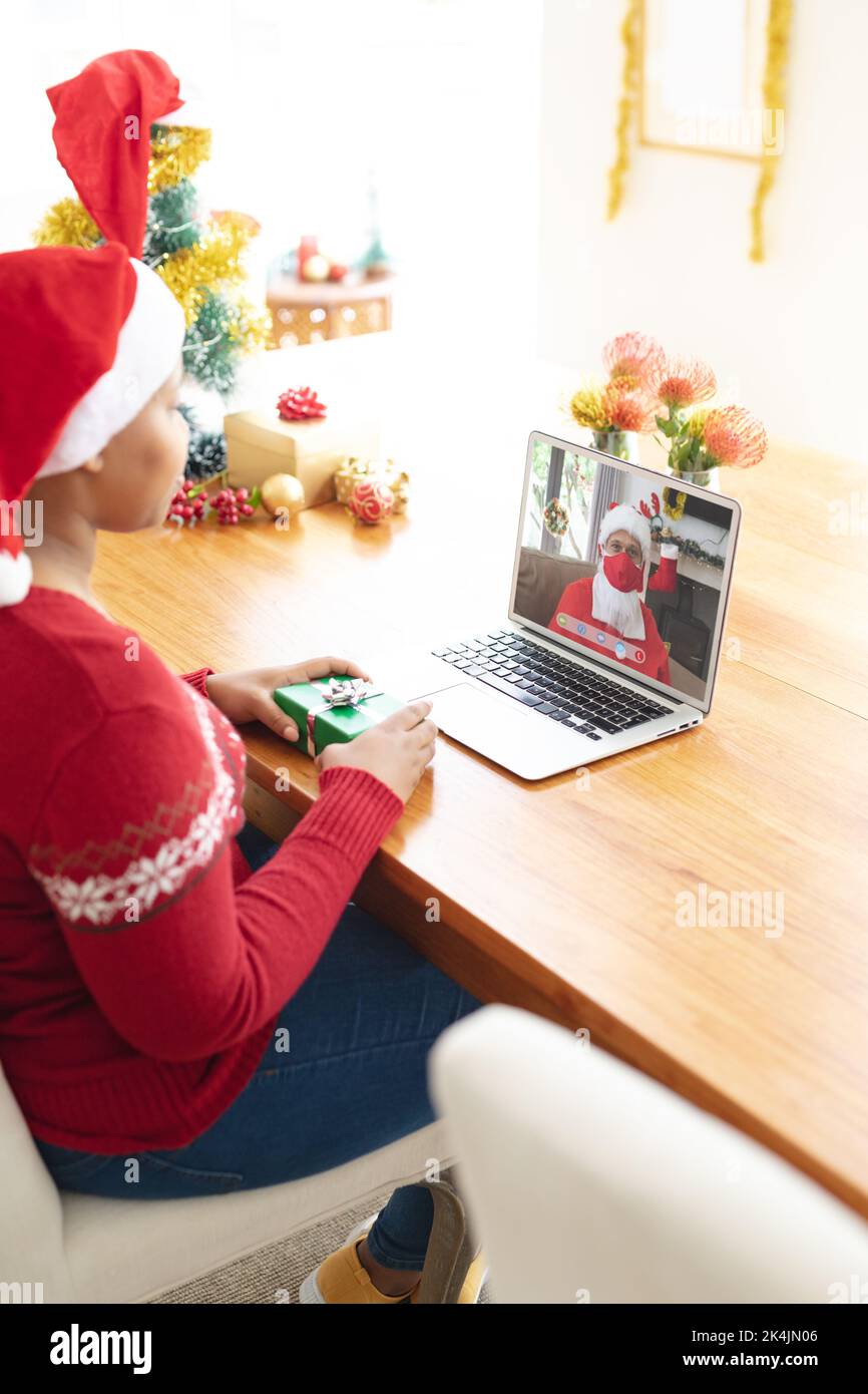 African american woman in santa hat making laptop christmas video call ...