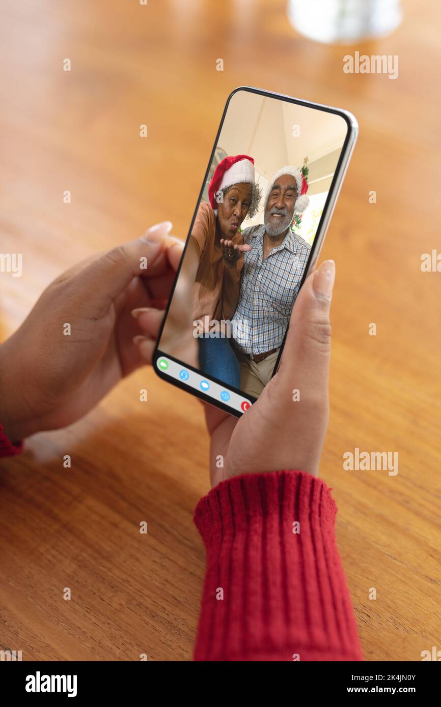 Hands holding smartphone with happy senior african american couple on ...