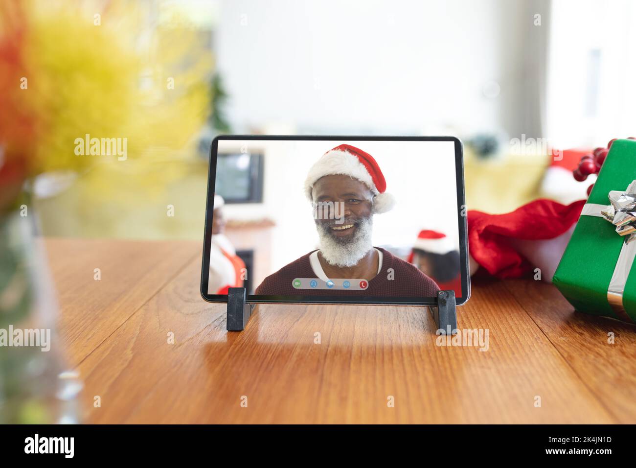 Smiling senior african american man in santa hat on tablet christmas ...